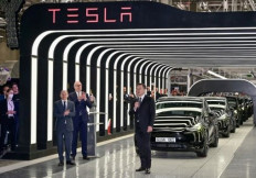Then-German chancellor Olaf Scholz (left) and Brandenburg state premier Dietmar Woidke (center) applaud as Tesla CEO Elon Musk speaks at an event on March 22, 2022 to kick-start production at Tesla's gigafactory in Gruenheide, southeast of Berlin.