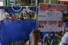 Local residents observe the tabulation of votes at Petamburan Polling Station (TPS) 5 in Tanah Abang, Central Jakarta, after the polls closed for the simultaneous regional head elections on Nov. 27, 2024.