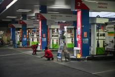 Attendants conduct general maintenance on March 4, 2025, as they wait for customers at a Pertamina gas station in Surabaya, East Java.