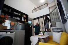 Visitors look at a mock up of a “mini“ subsidized house measuring 14 square meters in Jakarta on June 12, 2025. The  Housing and Settlement Ministry in collaboration with the property developer Lippo Group introduced mock-ups of subsidized houses measuring 14 square meters and 23.4 square meters, which are planned to be sold starting at Rp 105 million (US$6,422).