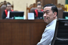 Former trade minister and graft defendant Thomas Lembong looks at journalists ahead of the verdict hearing at the Jakarta Corruption Court in Jakarta on July 18, 2025. A panel of judges sentenced Thomas to four-and-a-half years in prison and a Rp 750 million (US$45,871) fine after finding him guilty in a corruption case pertaining to sugar imports.